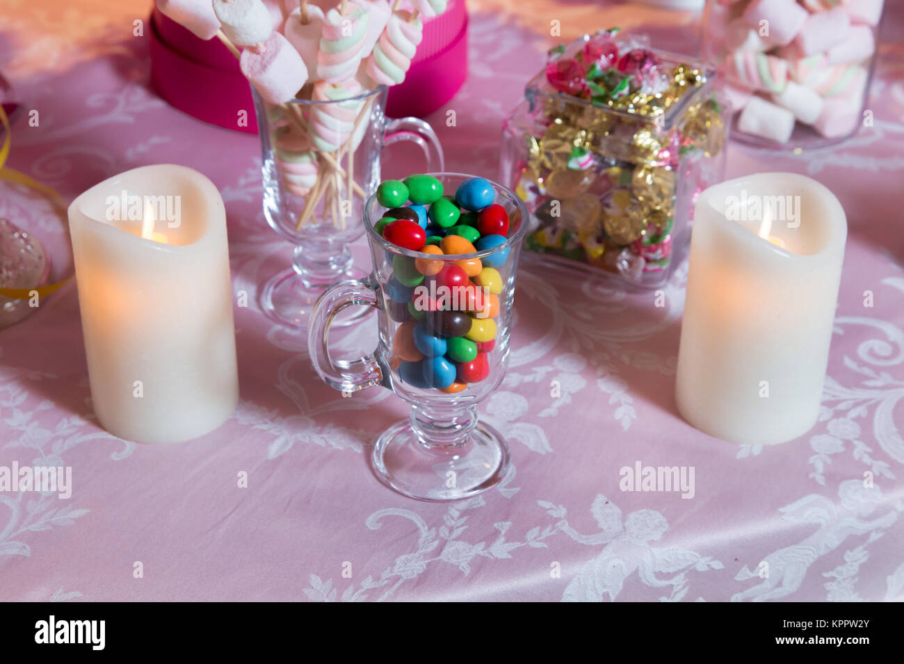 Multi colored sweets . Colored candy in a glass . Round chocolate is ...