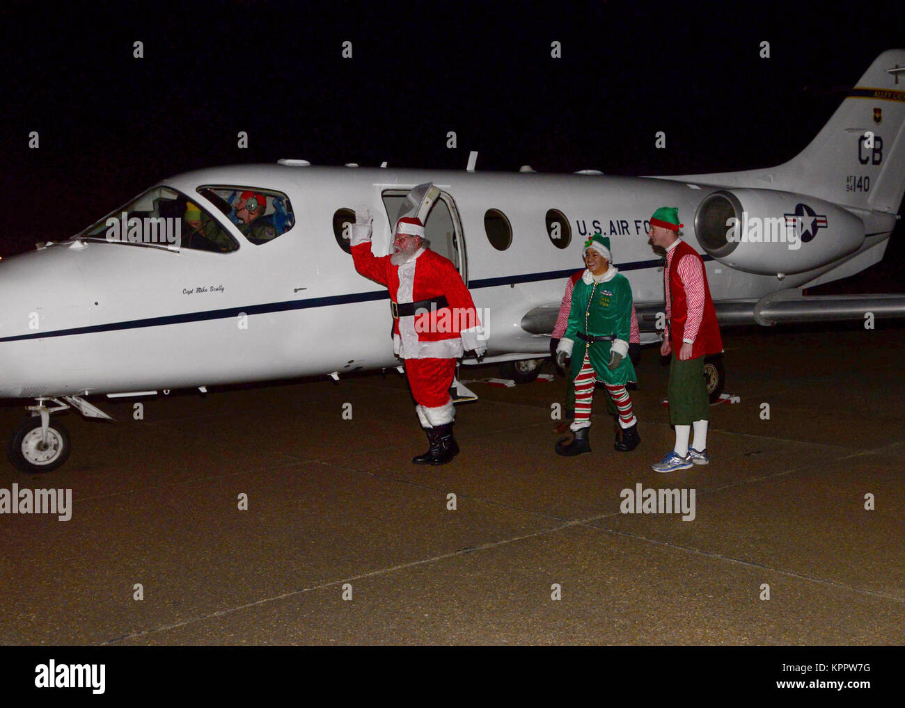 Santa Claus and three of his elves exit a T-1A Jayhawk, piloted by ...