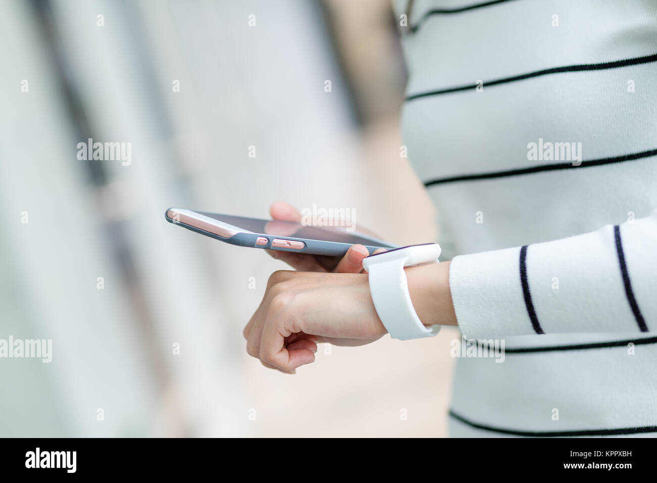 Young Woman using wearable watch connecting to mobile phone Stock Photo ...