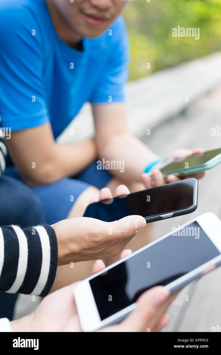 Group of people using cellphone together Stock Photo - Alamy