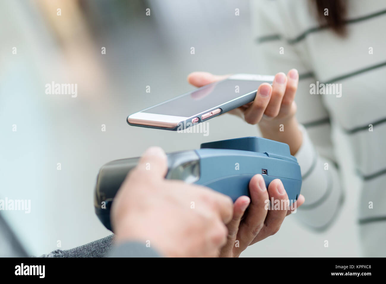 Woman using cellphone to pay Stock Photo - Alamy