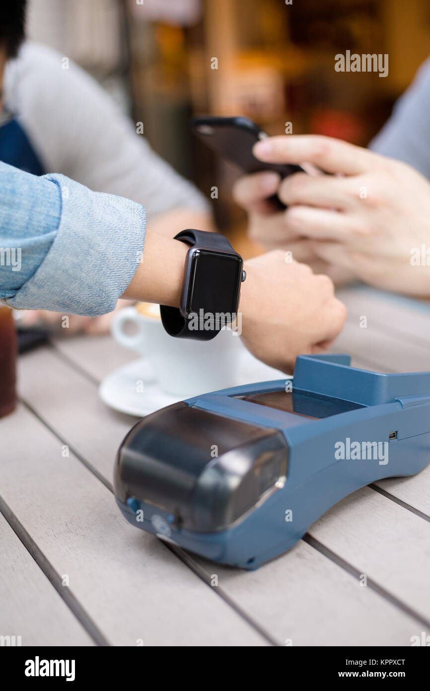 Customer pay by smart watch on pos machine Stock Photo - Alamy