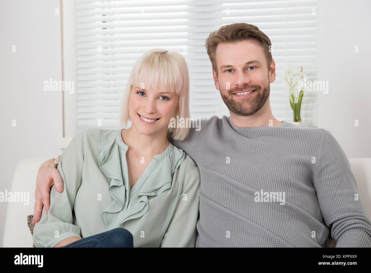 Couple Sitting Close Together On Sofa Stock Photo - Alamy
