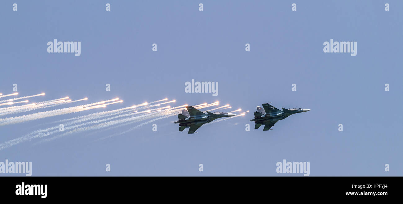 Aircraft fighter flies and shoots heat guns in the blue sky Stock Photo ...