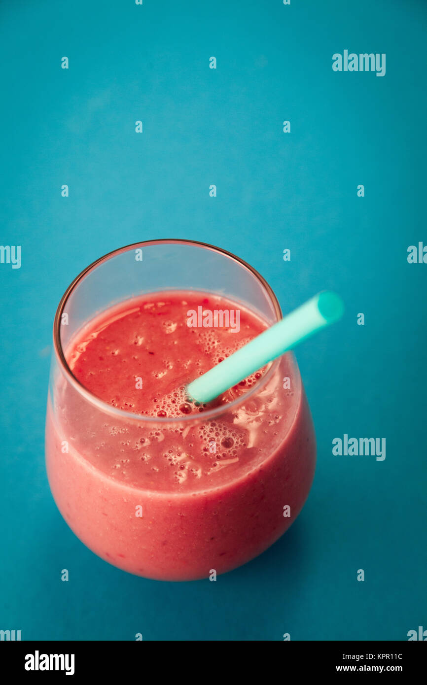Bright red Fruit Smoothie with Blue Background Stock Photo - Alamy