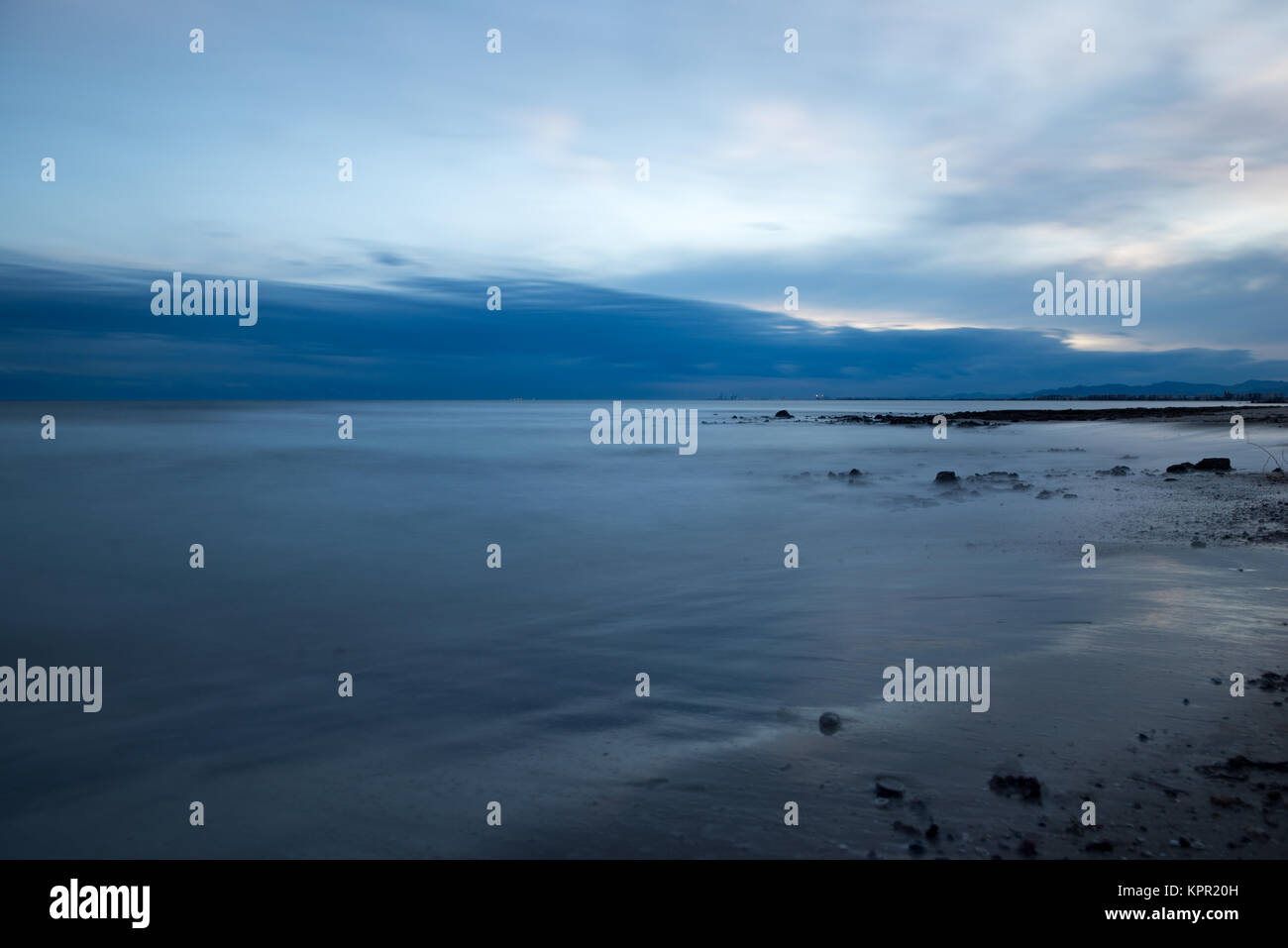 The calm sea in a very cloudy sunset in Spain Stock Photo - Alamy