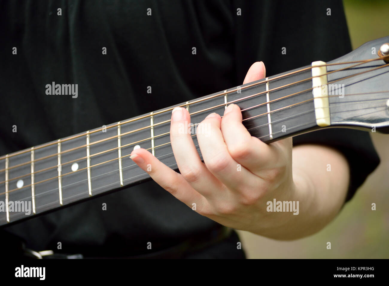 Closeup of guitar neck with guitarist playing Stock Photo - Alamy
