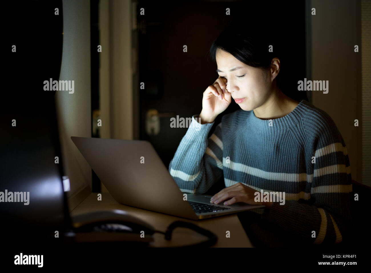 Woman having eye problem when using laptop computer Stock Photo - Alamy