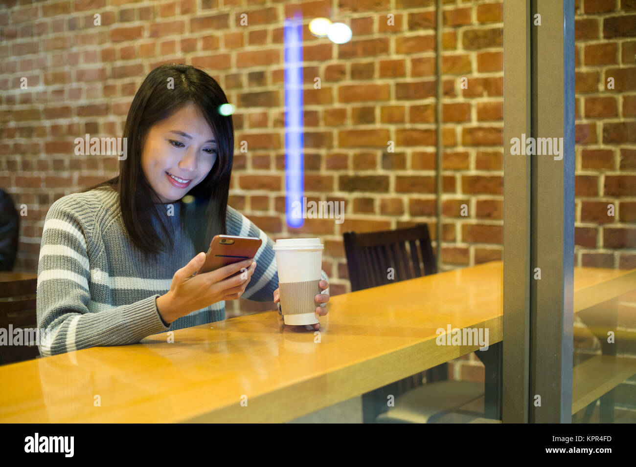 Woman using cellphone inside coffee shop Stock Photo - Alamy