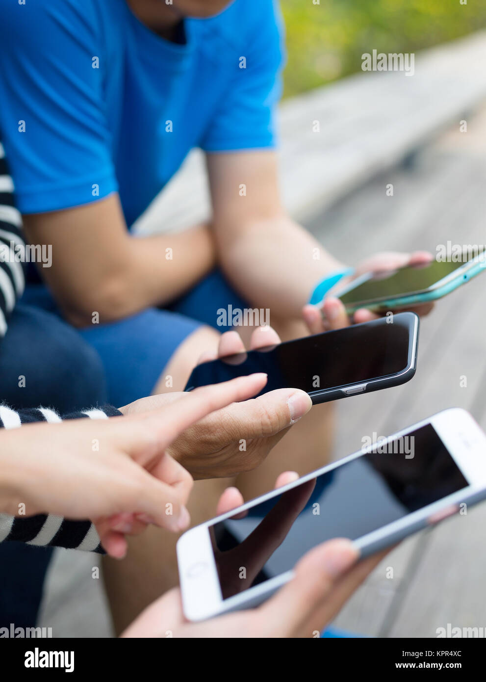 Friends using cellphone together Stock Photo - Alamy