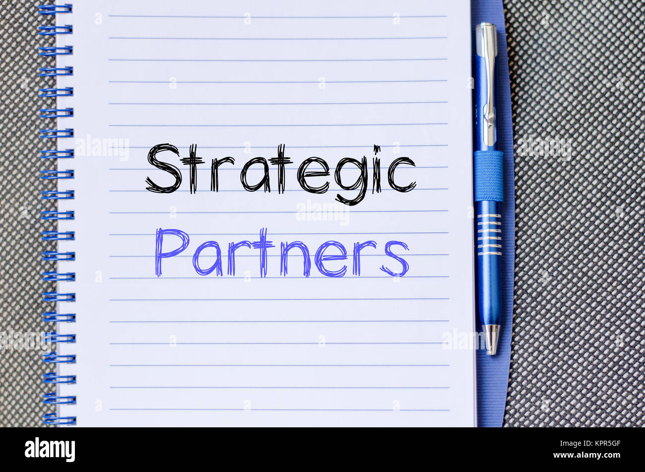 Strategic partners write on notebook Stock Photo - Alamy