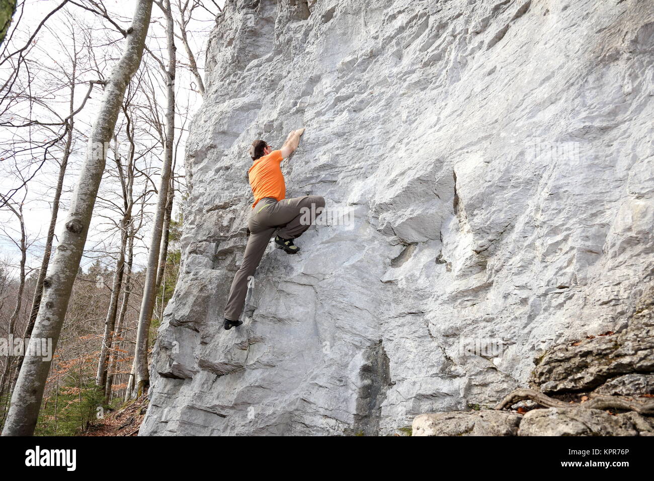 Sportler klettert an Felswand Stock Photo - Alamy