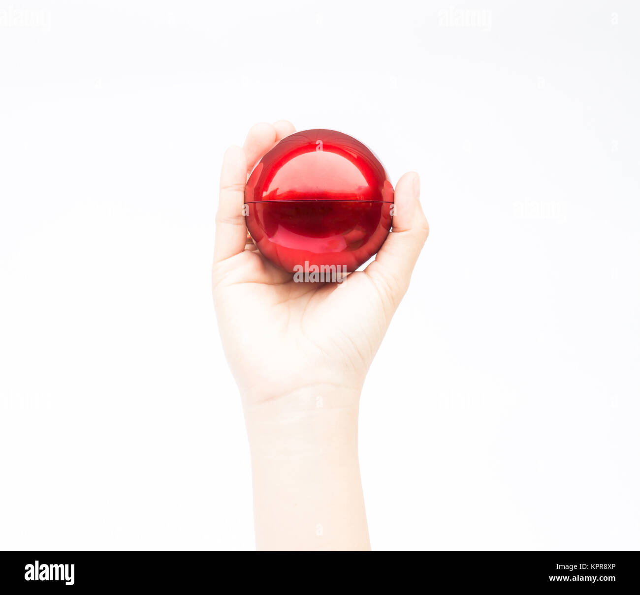 Hand on shiny red ball on white background Stock Photo - Alamy