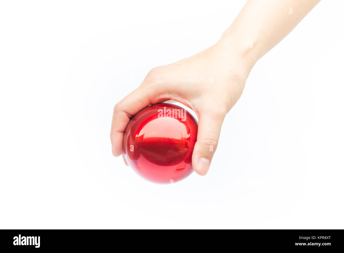 Hand on shiny red ball on white background Stock Photo - Alamy