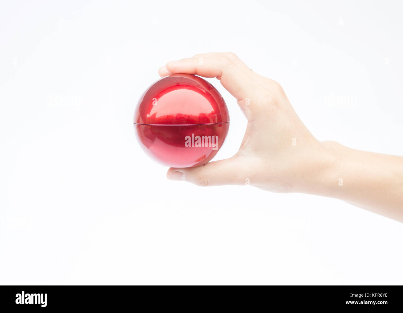 Hand on shiny red ball on white background Stock Photo - Alamy