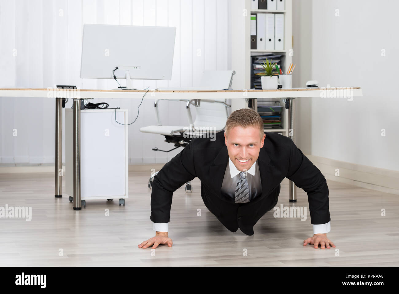 Businessman Doing Pushup At Work Stock Photo - Alamy