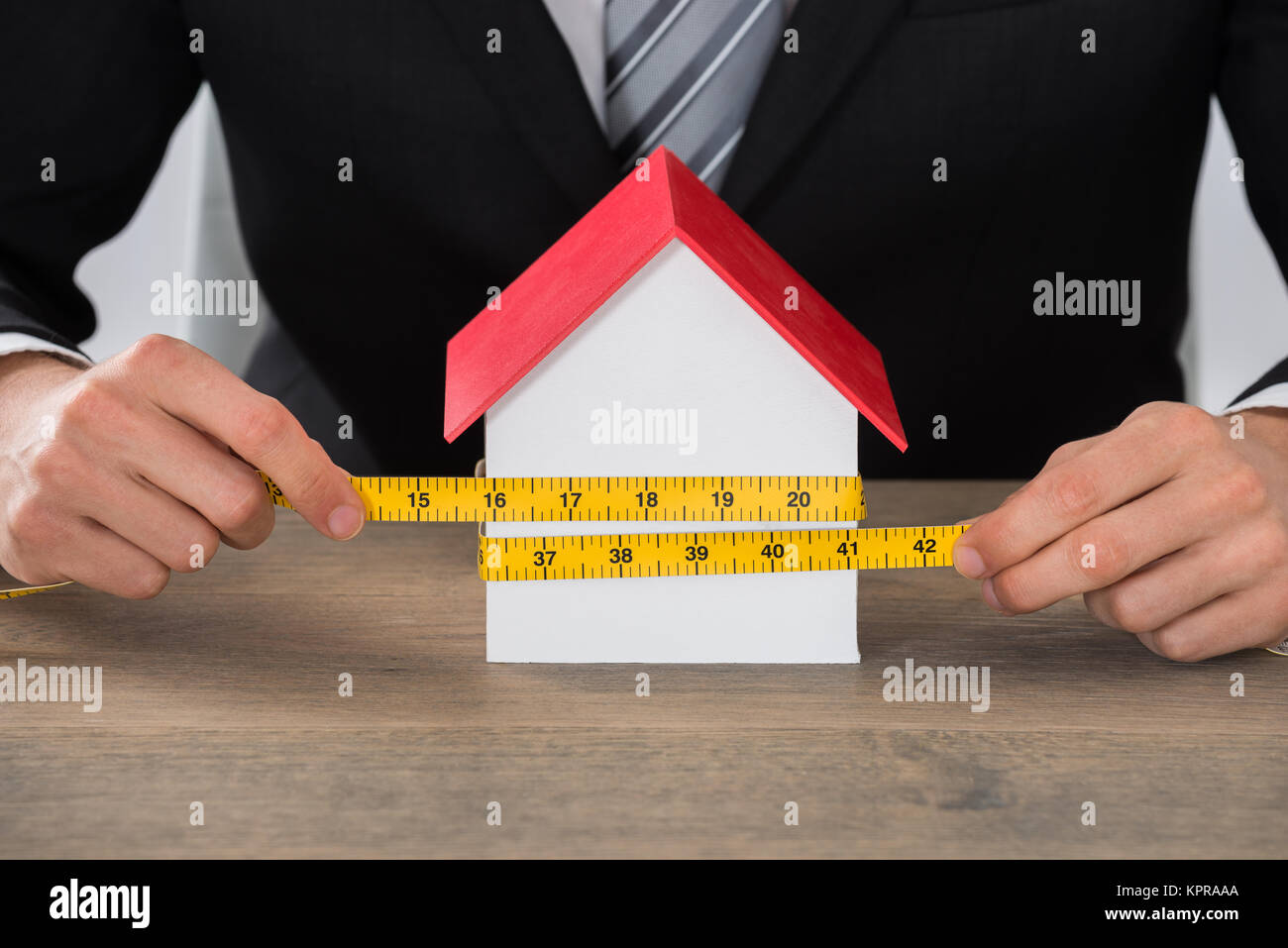 Businessman Hand Measuring House Model Stock Photo - Alamy
