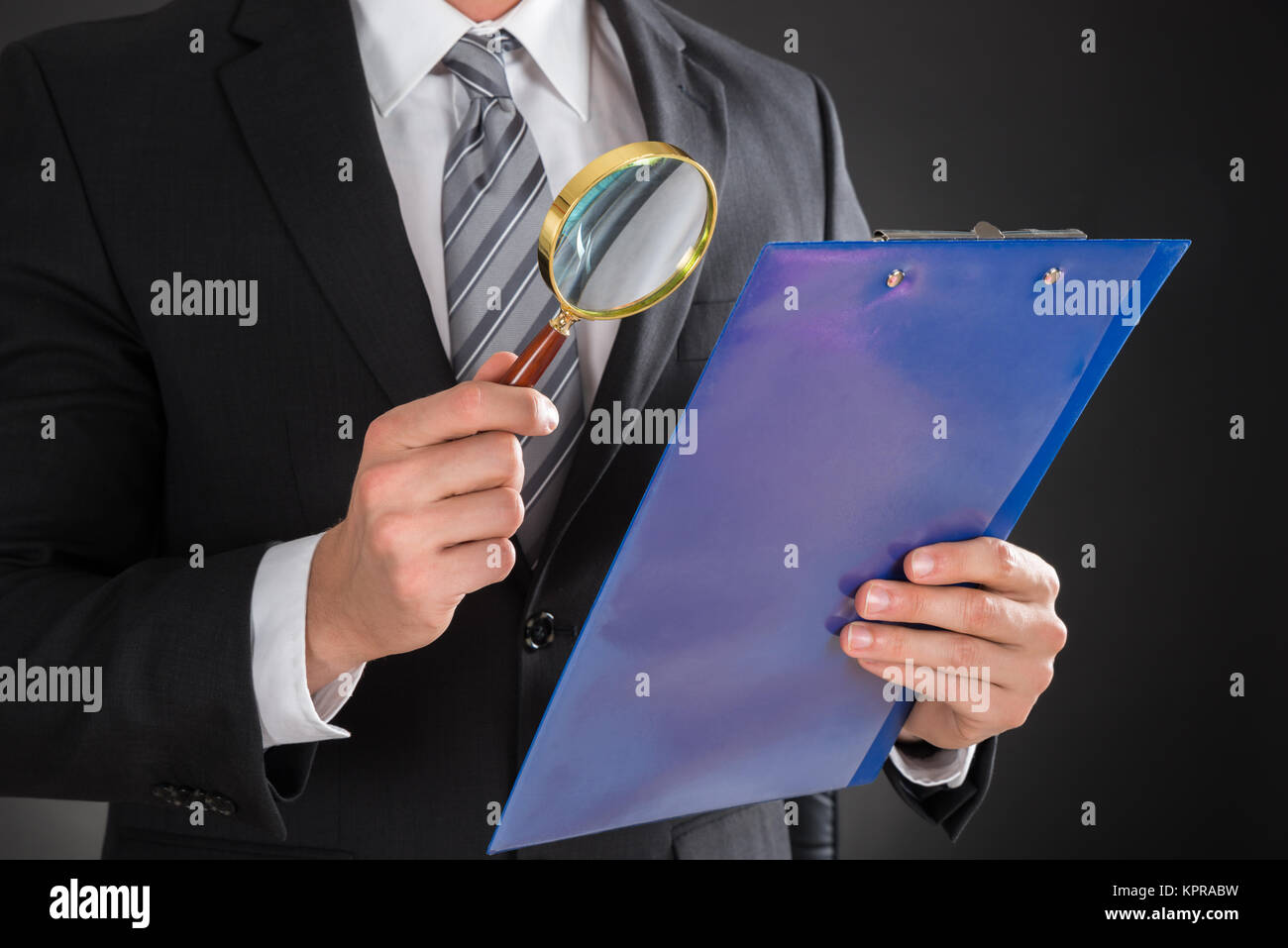 Businessman Examining Document On Clipboard Stock Photo - Alamy