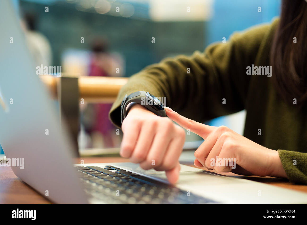 Woman use of smart watch connect with laptop computer Stock Photo - Alamy