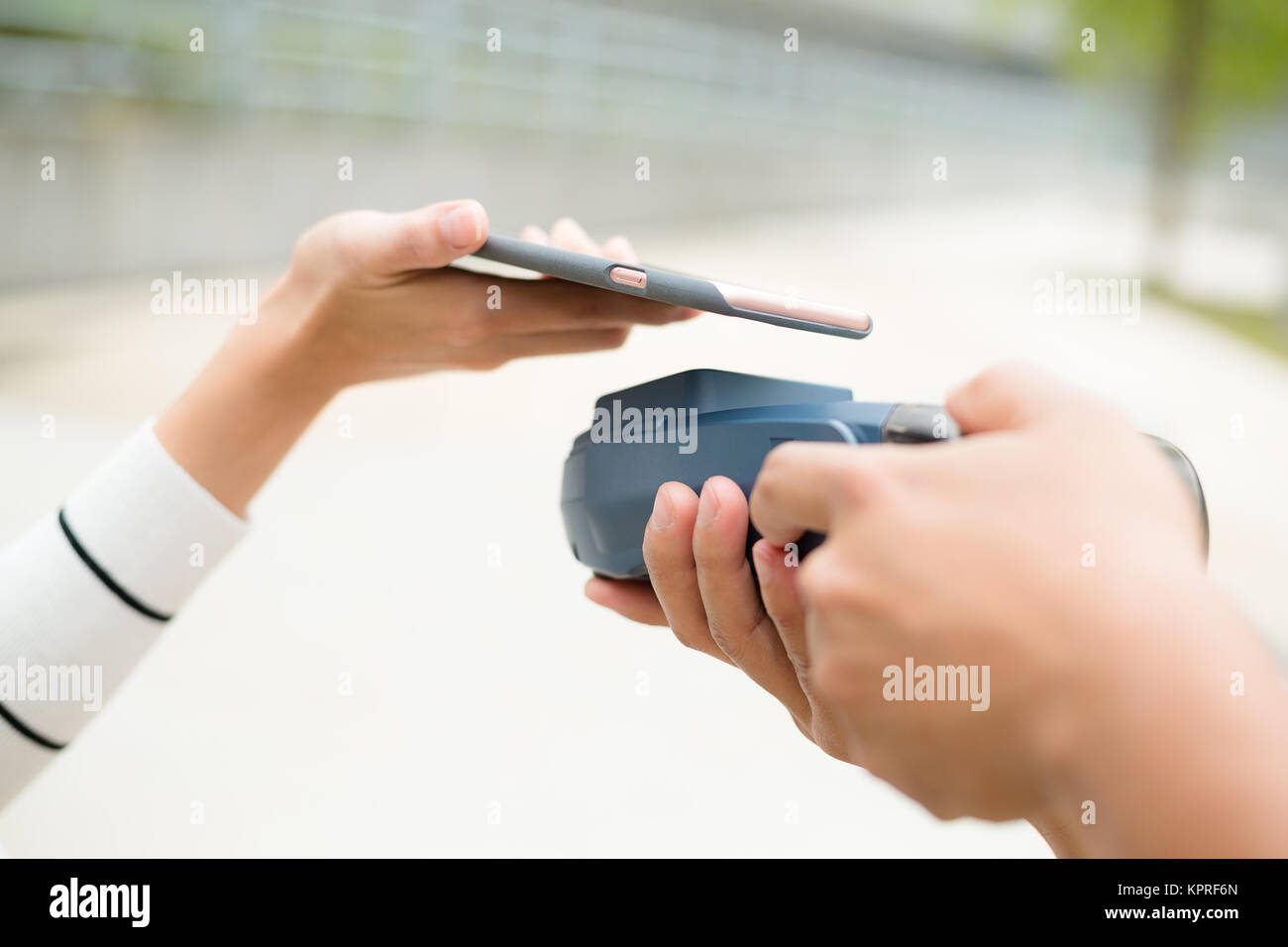 Customer using mobile phone to pay Stock Photo - Alamy