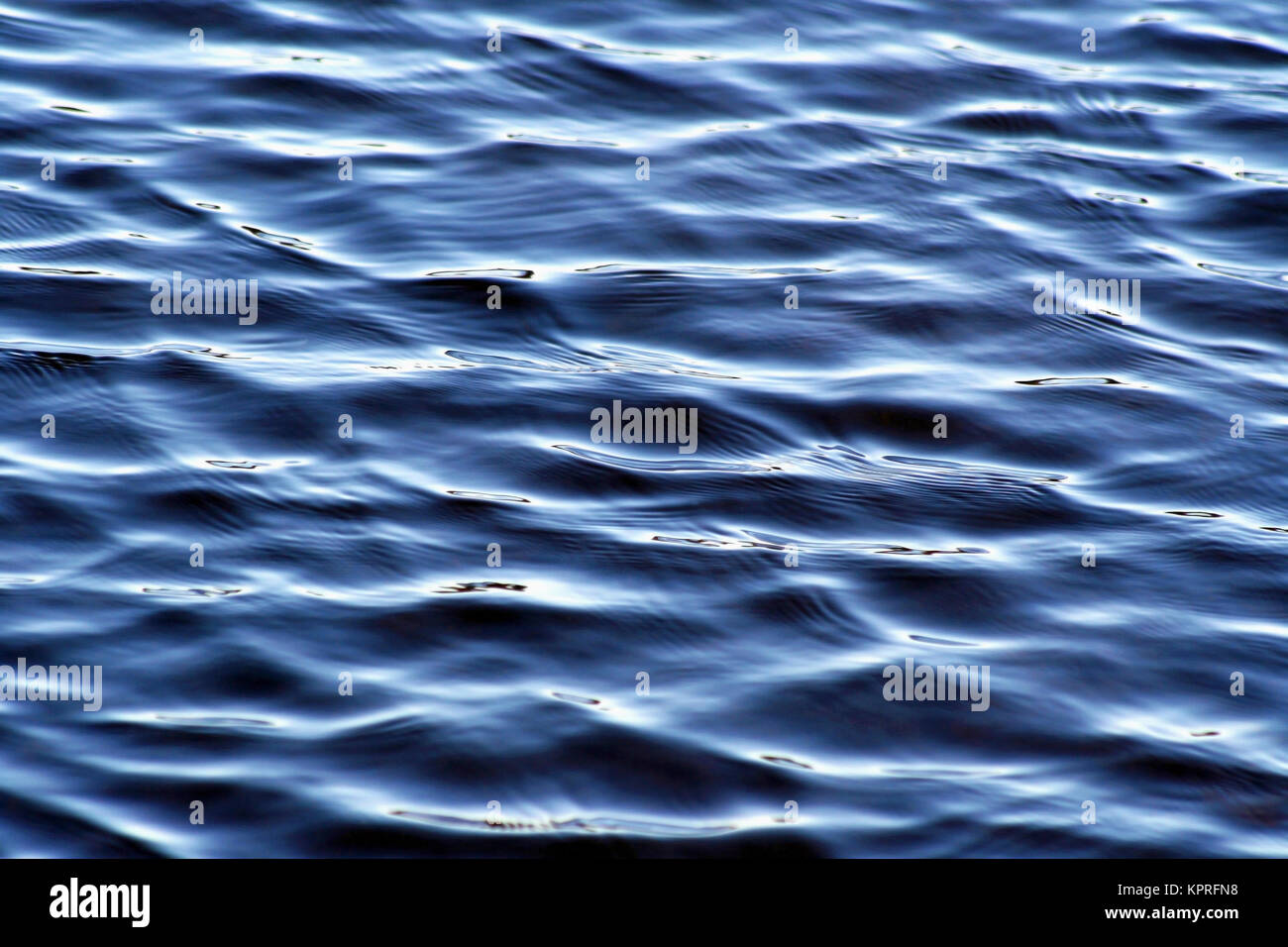 Soft ripples moving along surface of deep blue waters Stock Photo - Alamy
