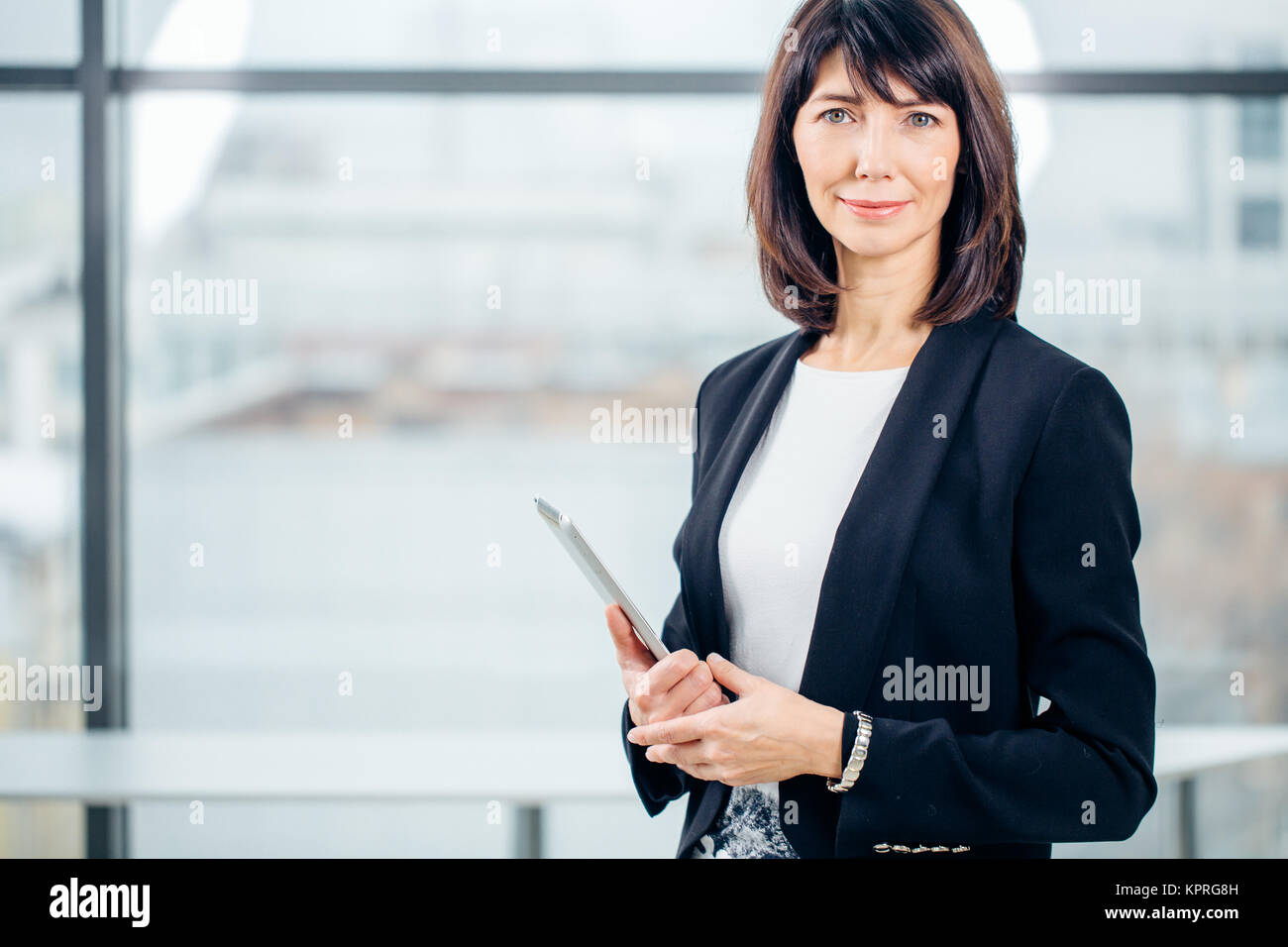 Female architect using tablet computer, looking to camera Stock Photo ...
