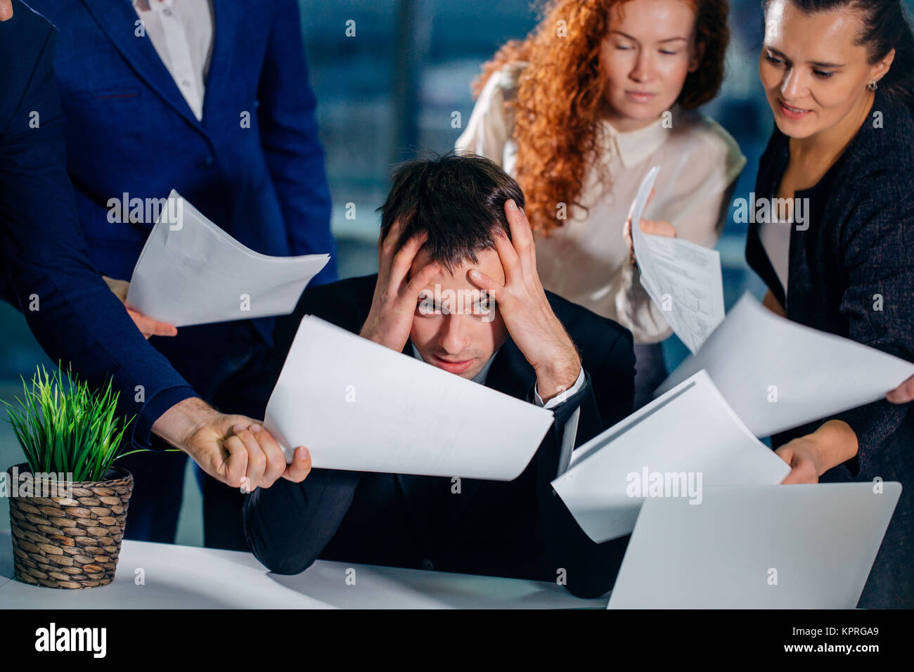 Stressed Business Man In Office surrounded by colleagues with documents ...