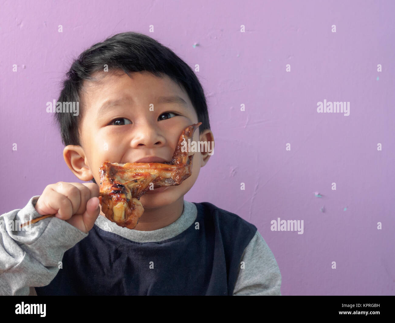asian boy eating roasted chicken wing Stock Photo - Alamy