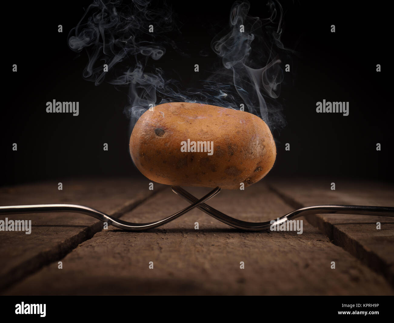 Hot potato on forks Stock Photo - Alamy