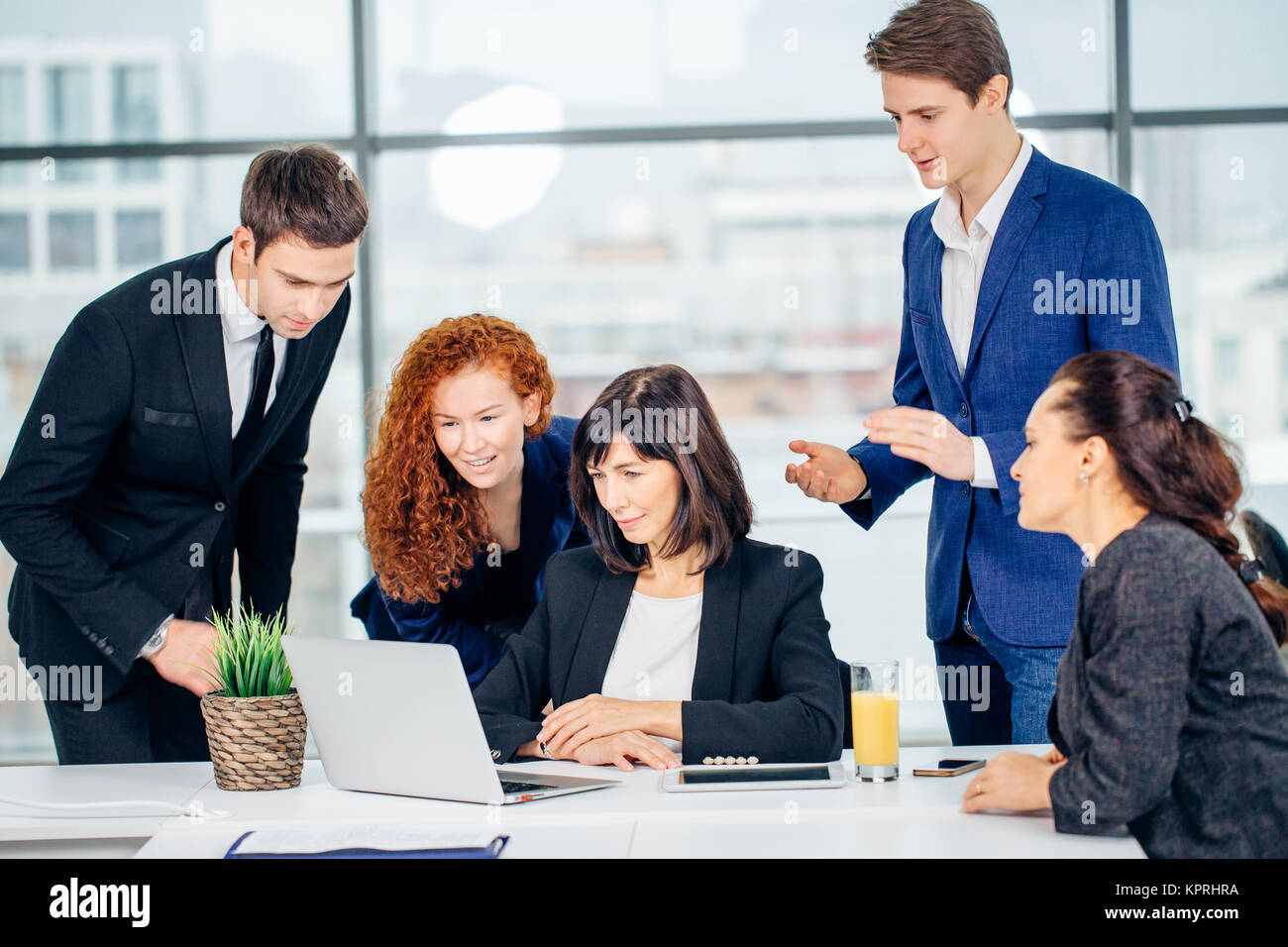 male and female business people around laptop computer in office Stock ...