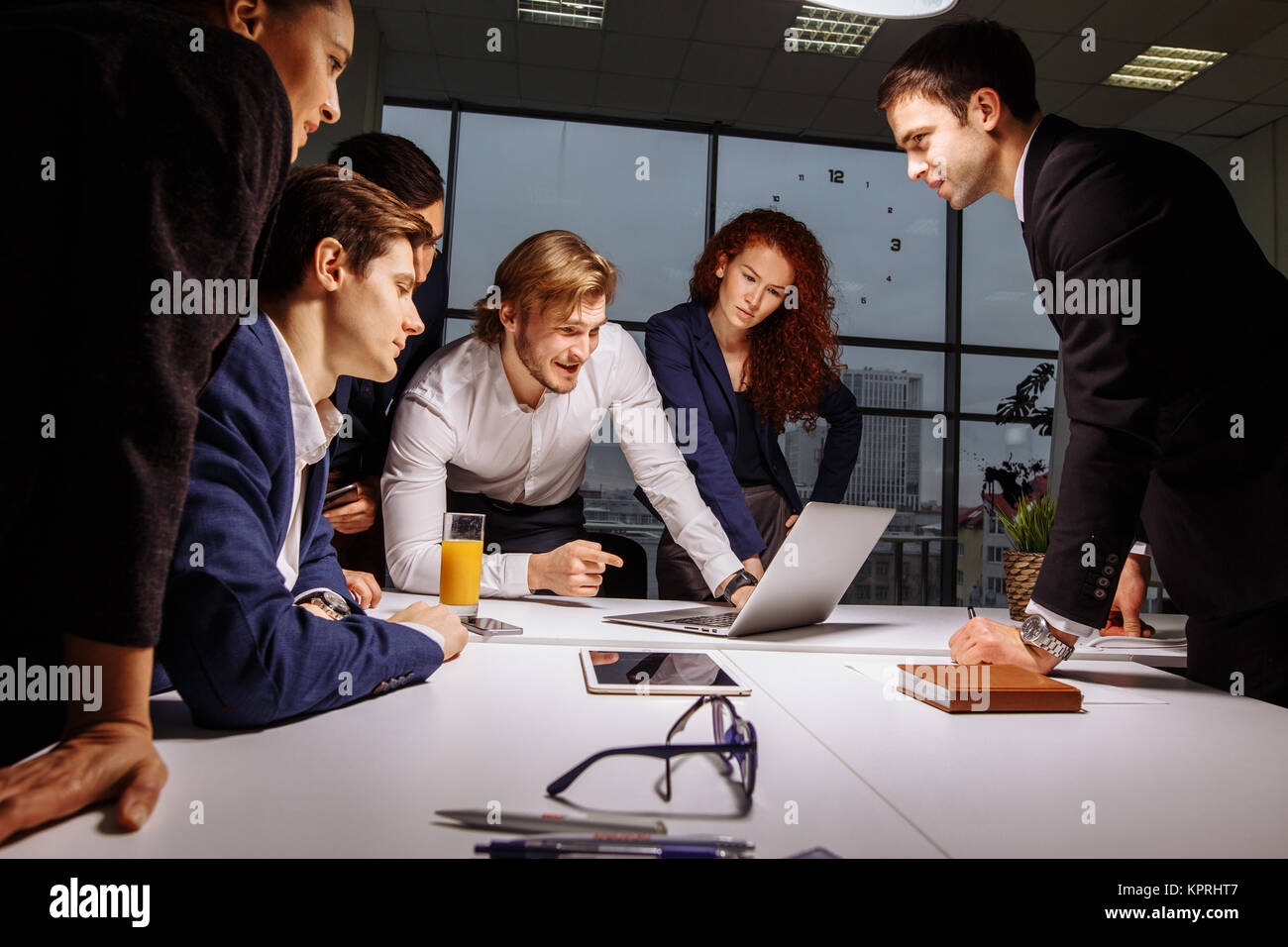 male and female business people around laptop computer in office Stock ...