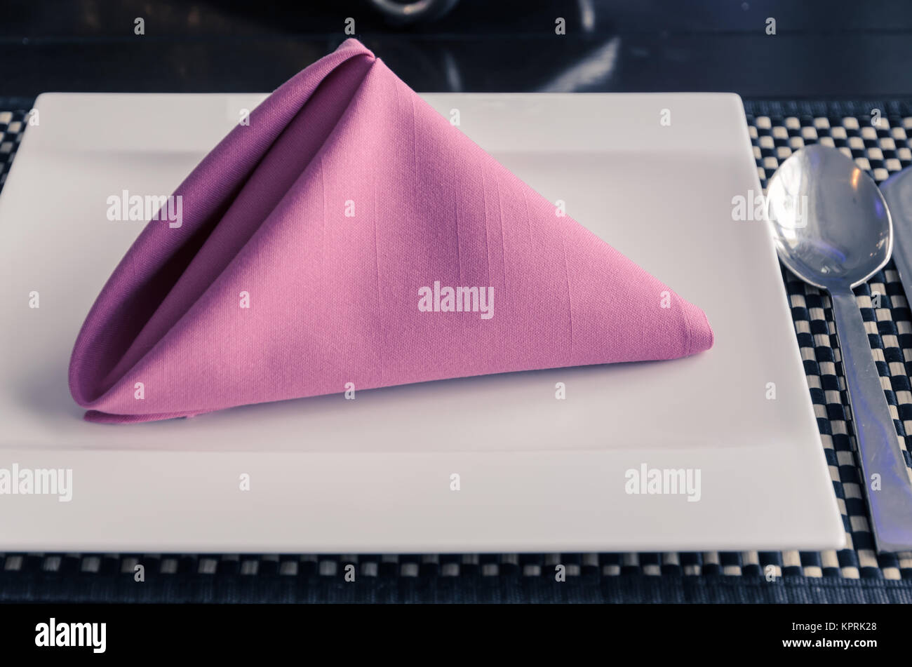 Folded napkin on white plate Stock Photo - Alamy