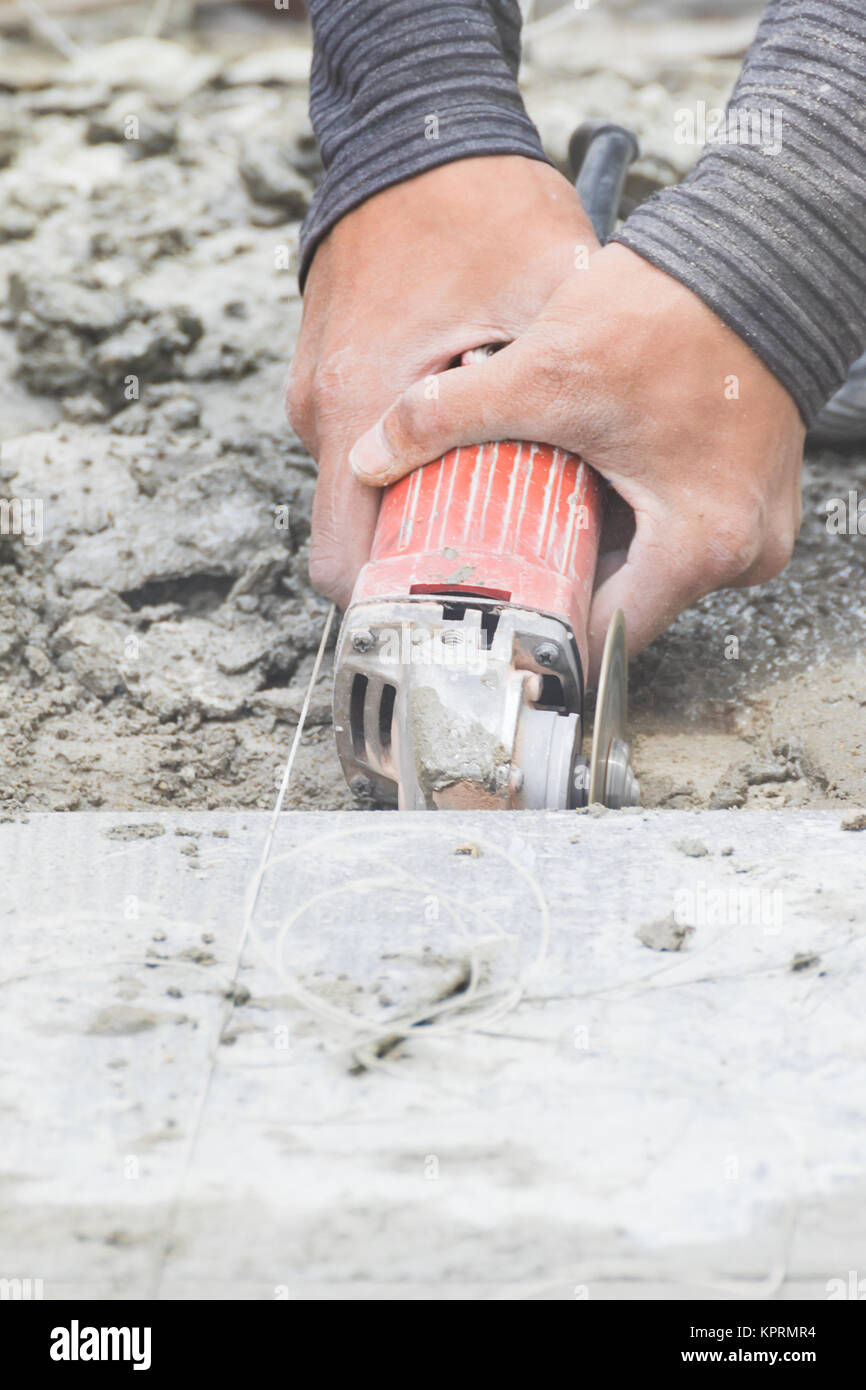 Mason cutting tiles to repair Stock Photo - Alamy