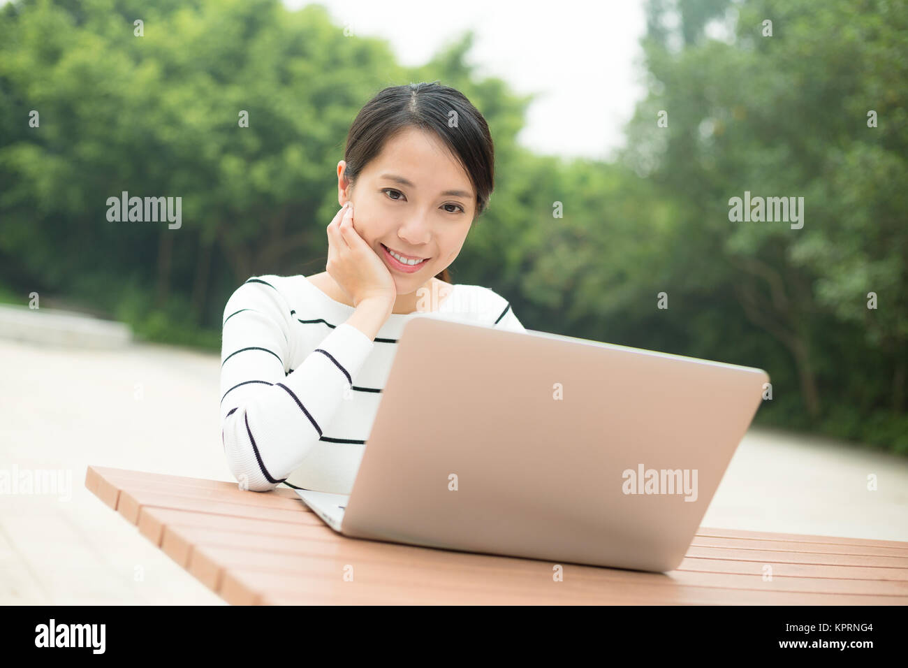 Woman use of laptop computer and sitting at outdoor Stock Photo - Alamy