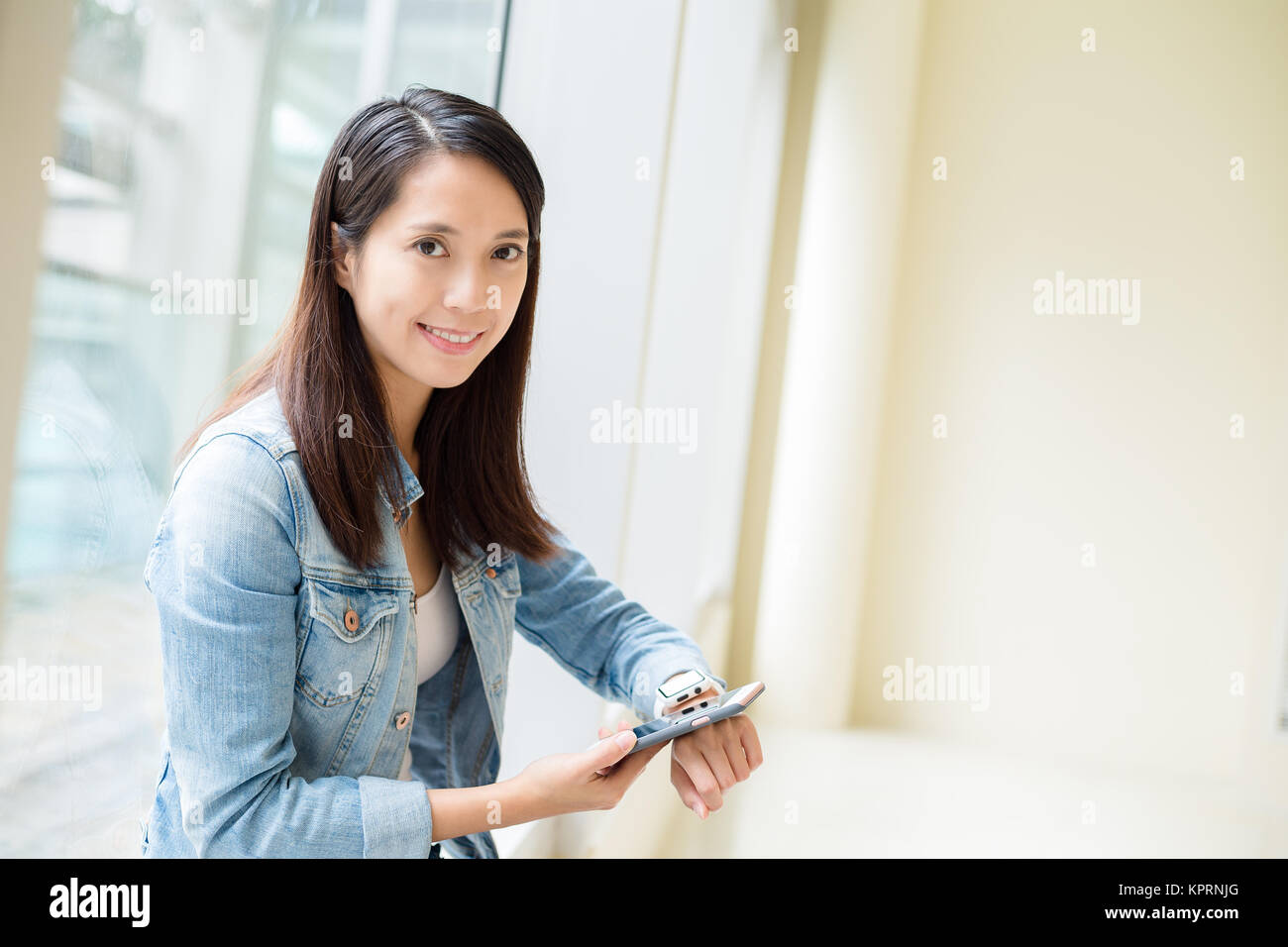 Woman connect the cellphone with smart watch Stock Photo - Alamy