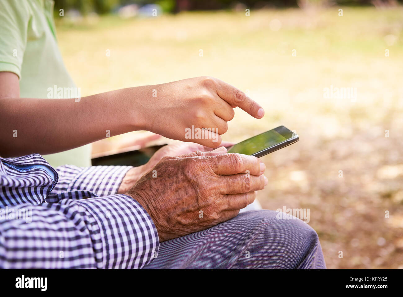 Child Helping Old Grandfather With Mobile Phone And Internet Stock ...