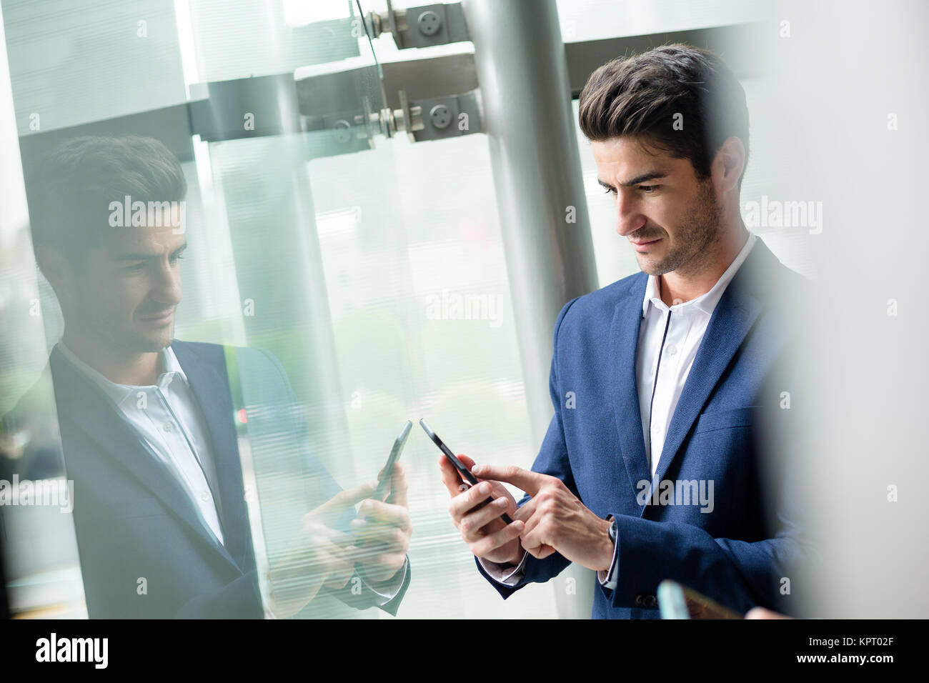 Businessman use of cellphone inside office building Stock Photo - Alamy