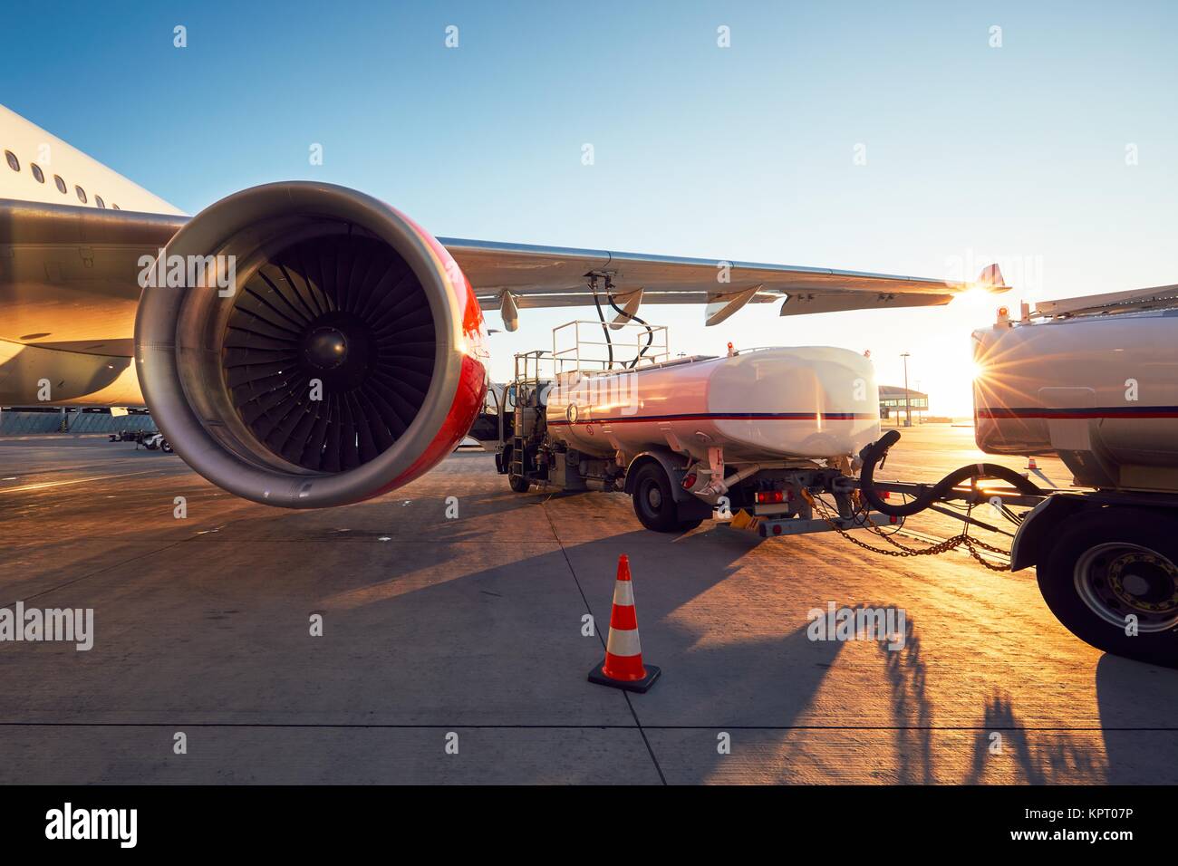 Amazing sunset at the airport. Refueling of the airplane before flight ...