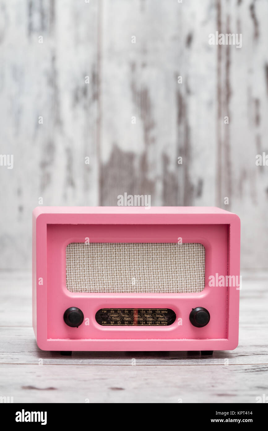 Pink radio with retro look on white wooden background Stock Photo - Alamy