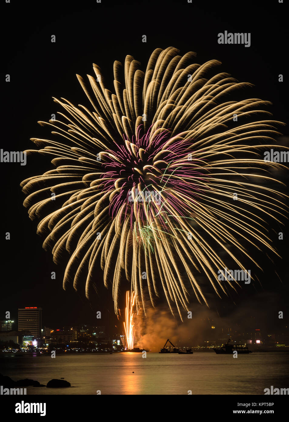 Big yellow firework on the sky at Pattaya coast with cityscape ...