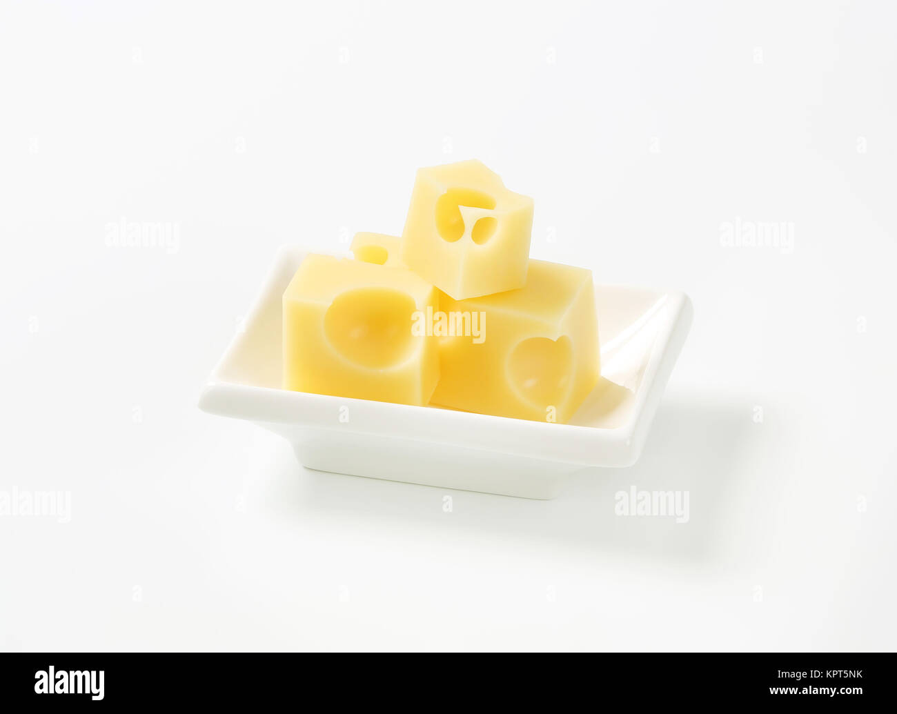 cubes of emmental cheese in white bowl Stock Photo - Alamy