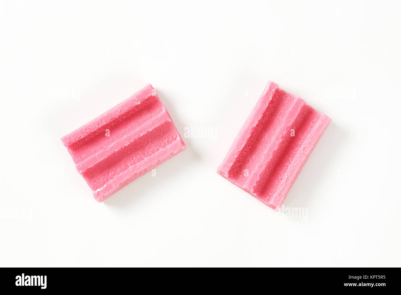 two pieces of pink chewing gum on white background Stock Photo - Alamy