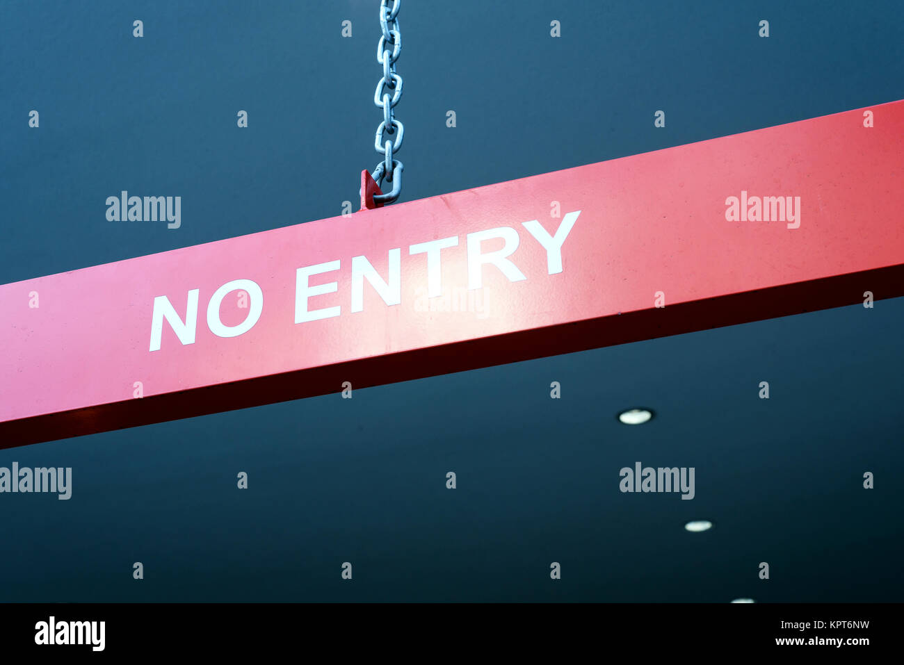 White text no entry sign on a red background hanging from a chain Stock ...