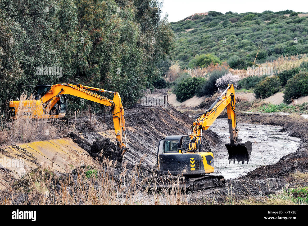 Large excavators engaged in cleaning of the riverbed of a river from ...