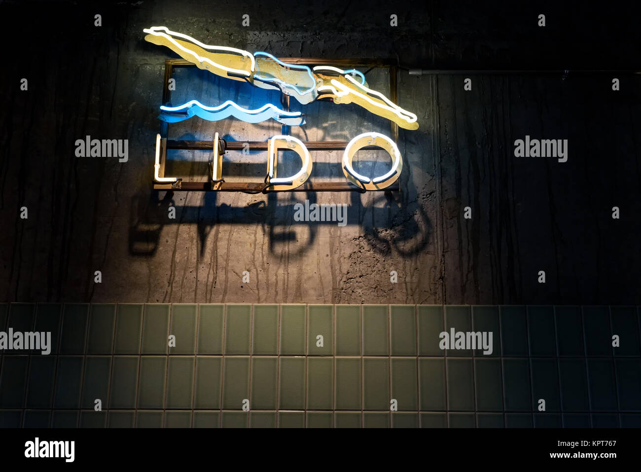 Lido swimming pool sign with a woman diving into wavy water in a neon ...