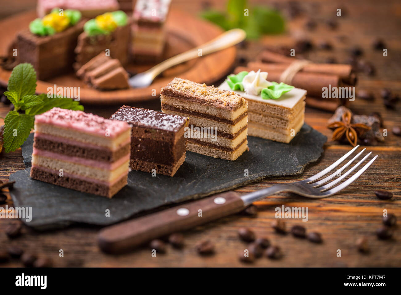 Small square cakes with different cream on black slate Stock Photo - Alamy