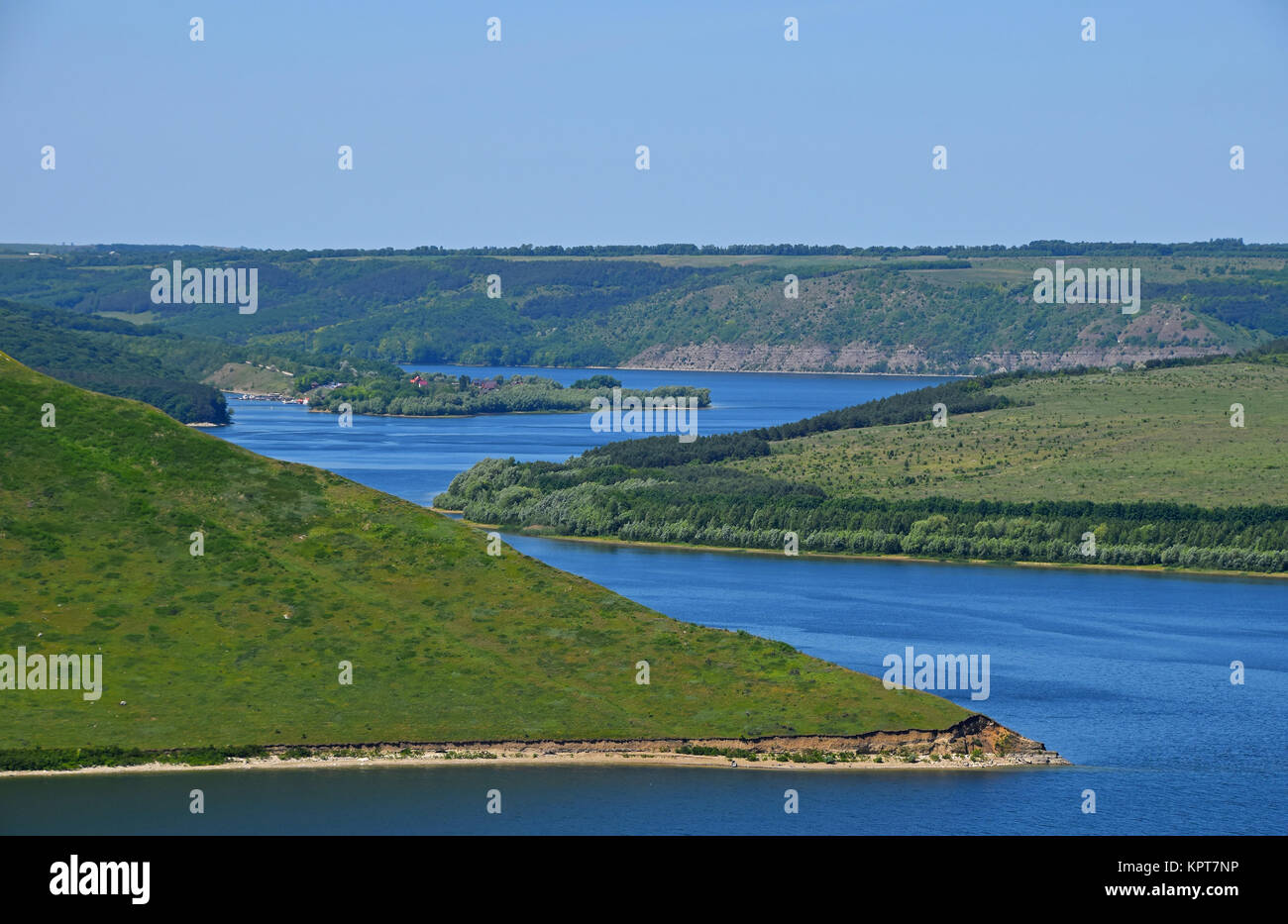 Beautiful vivid riverside landscape with high river banks, green hills ...