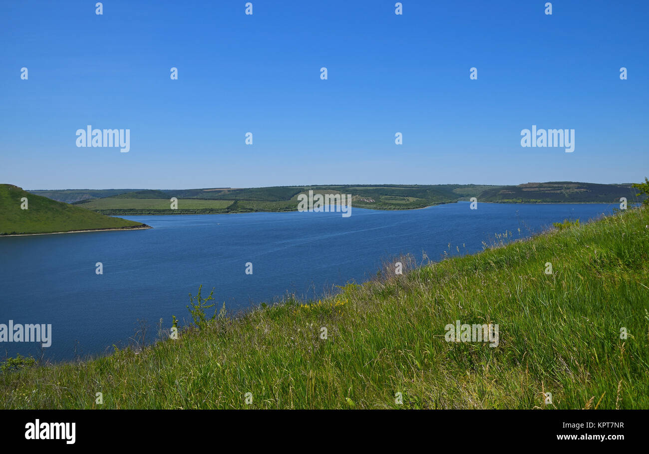 Beautiful vivid riverside landscape with high river banks, green hills ...