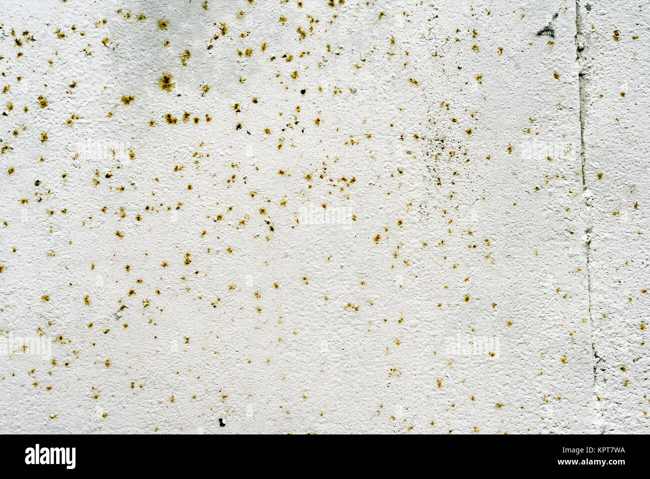 Painted flecks of peeling paint on an orange colour rust surface ...