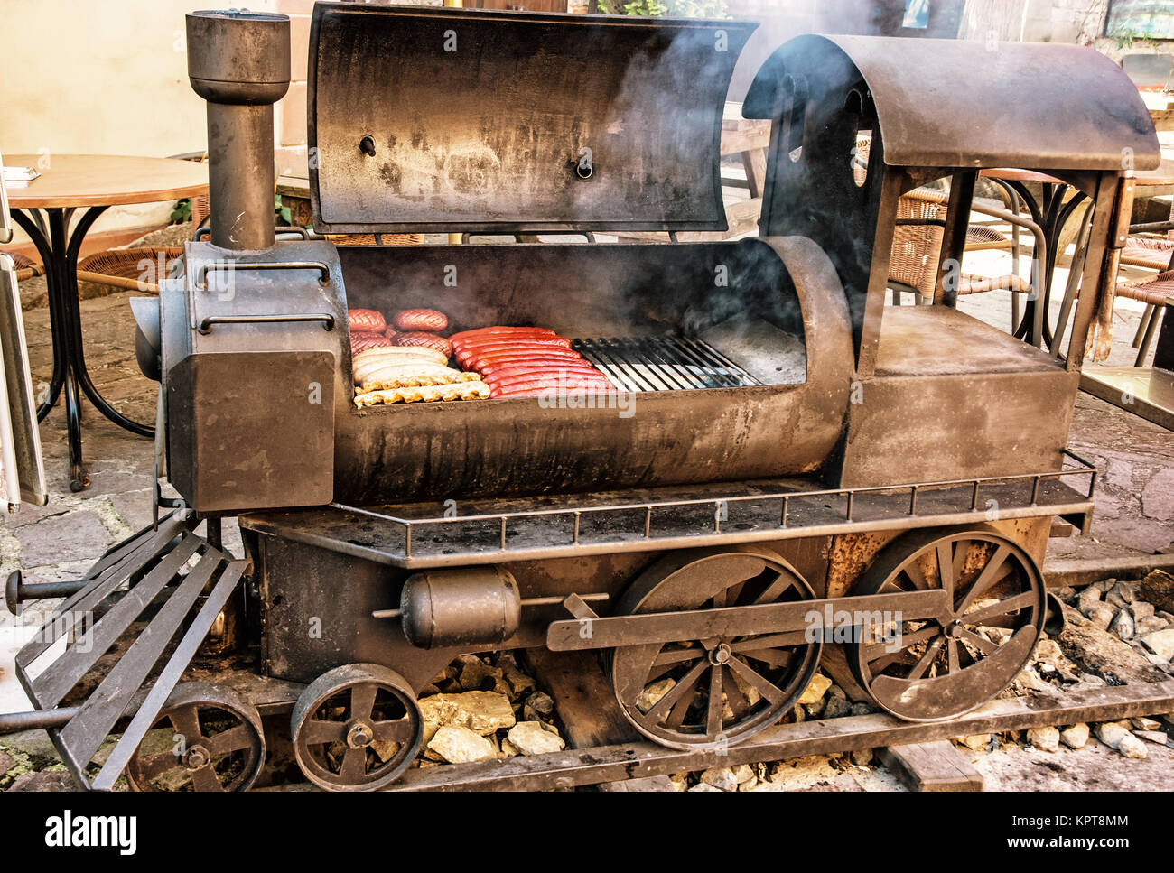 Barbecue grill with meat in shape of old steam locomotive. Bbq scene ...